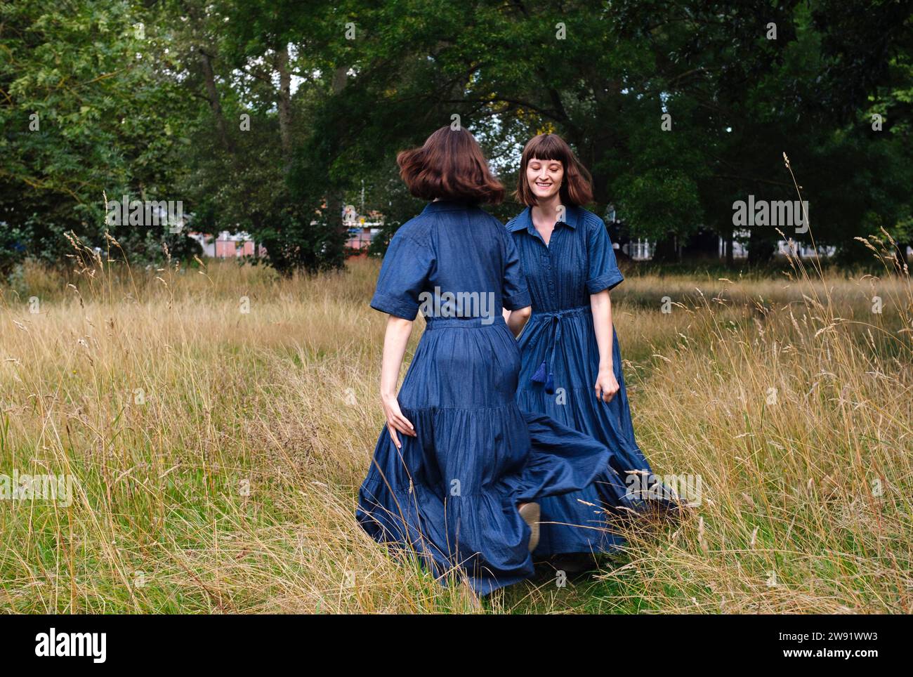 Happy twin sisters playing in park Stock Photo - Alamy