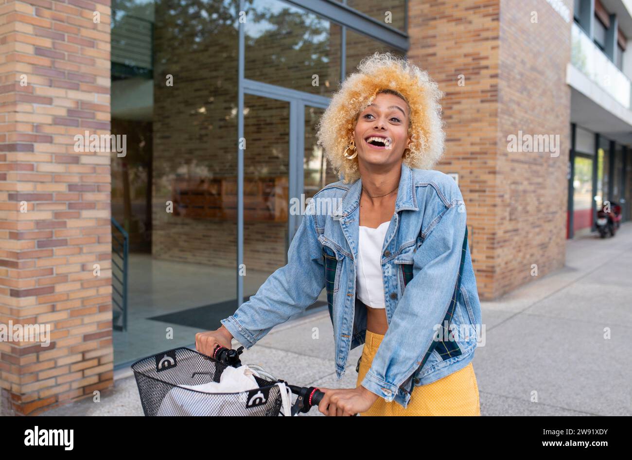 Happy transgender woman with bicycle near building Stock Photo - Alamy