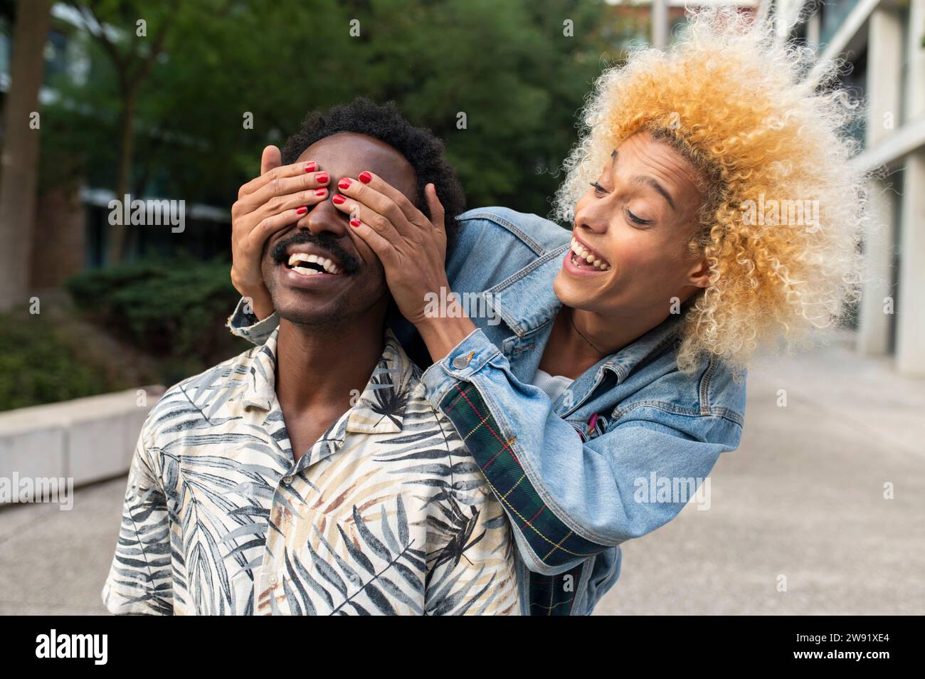 Happy transgender woman covering eyes of boyfriend Stock Photo - Alamy