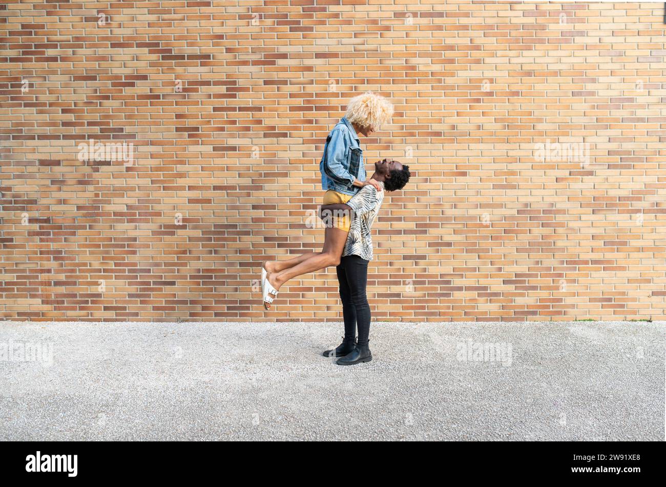 Young boyfriend having fun with transgender woman standing in front of ...