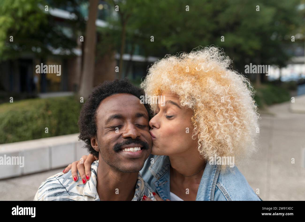 Young transgender woman with curly hair kissing boyfriend Stock Photo ...