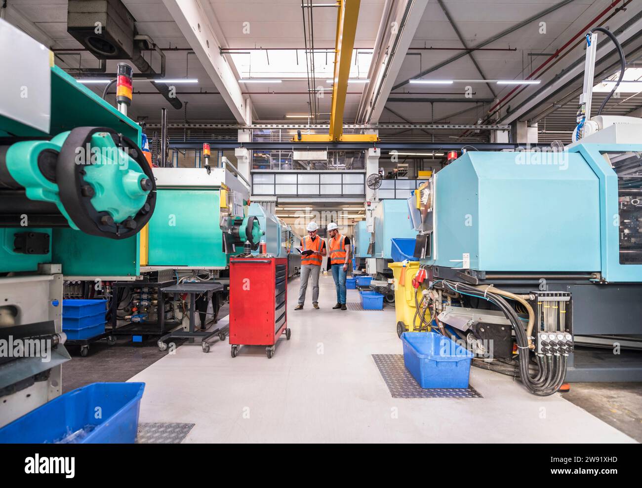Engineer colleagues examining machines at industry Stock Photo - Alamy
