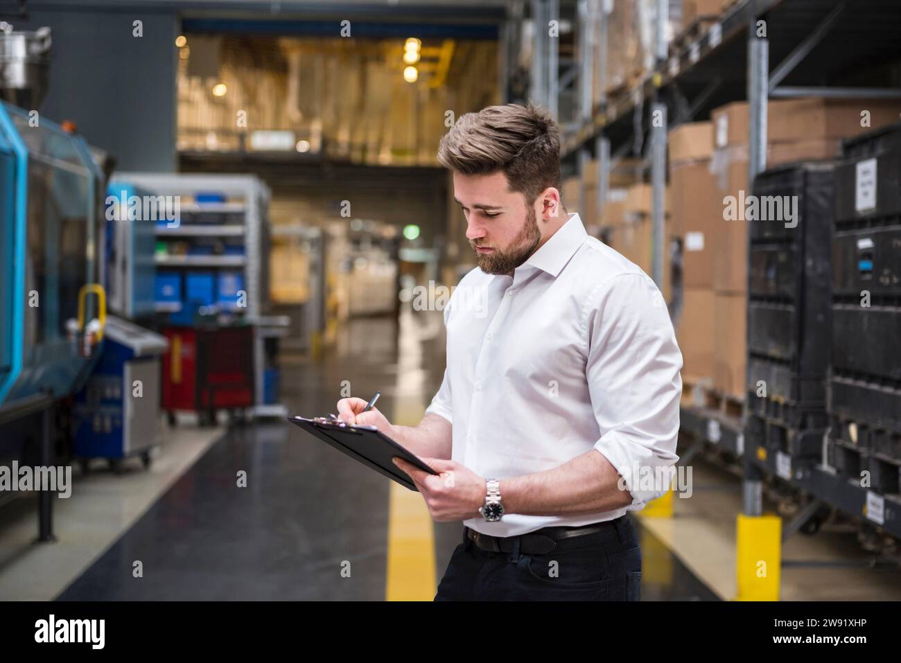 Inspector preparing report on clipboard at industry Stock Photo - Alamy