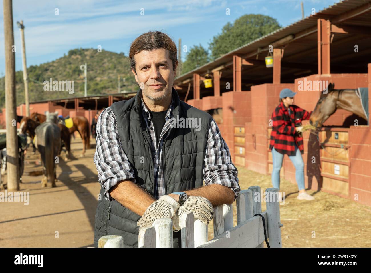 Portrait of positive adult man landowner wearing plaid shirt and posing ...
