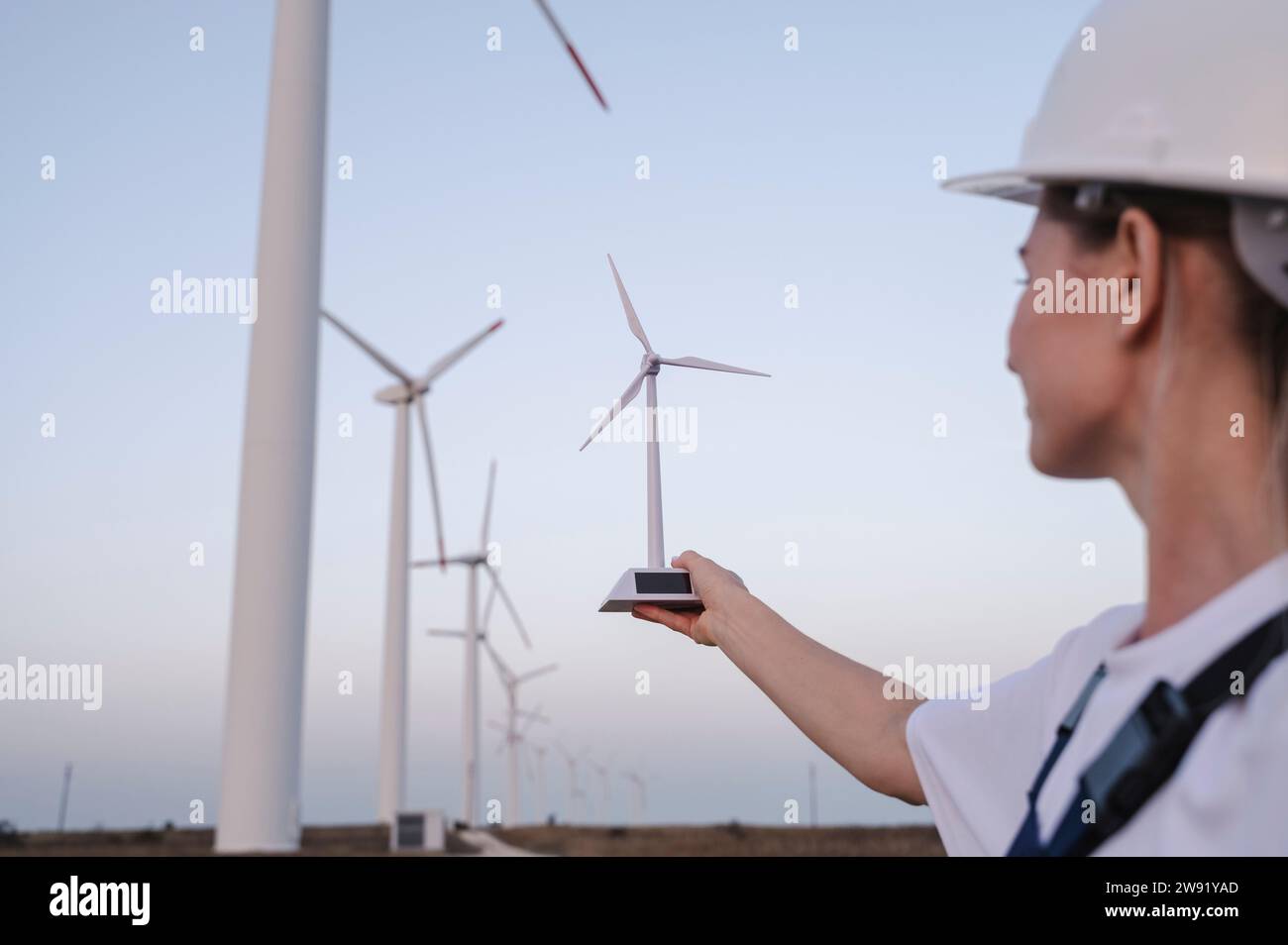 Engineer holding architectural model near wind turbines under sky Stock ...