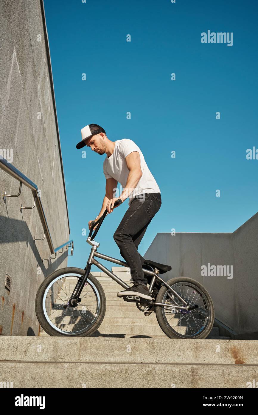Man riding BMX bike on staircase under sky Stock Photo - Alamy