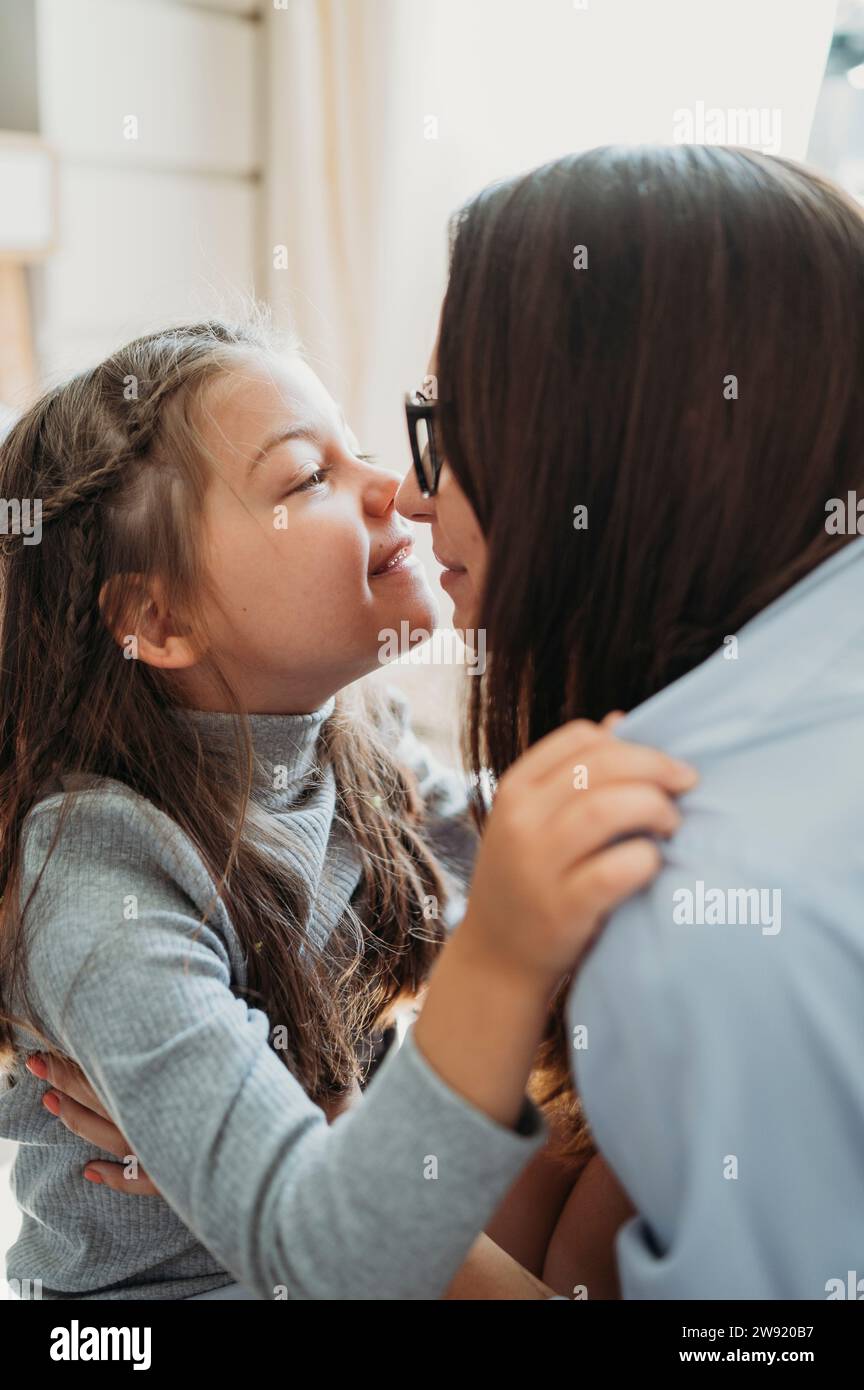 Loving mother rubbing nose with daughter at home Stock Photo - Alamy