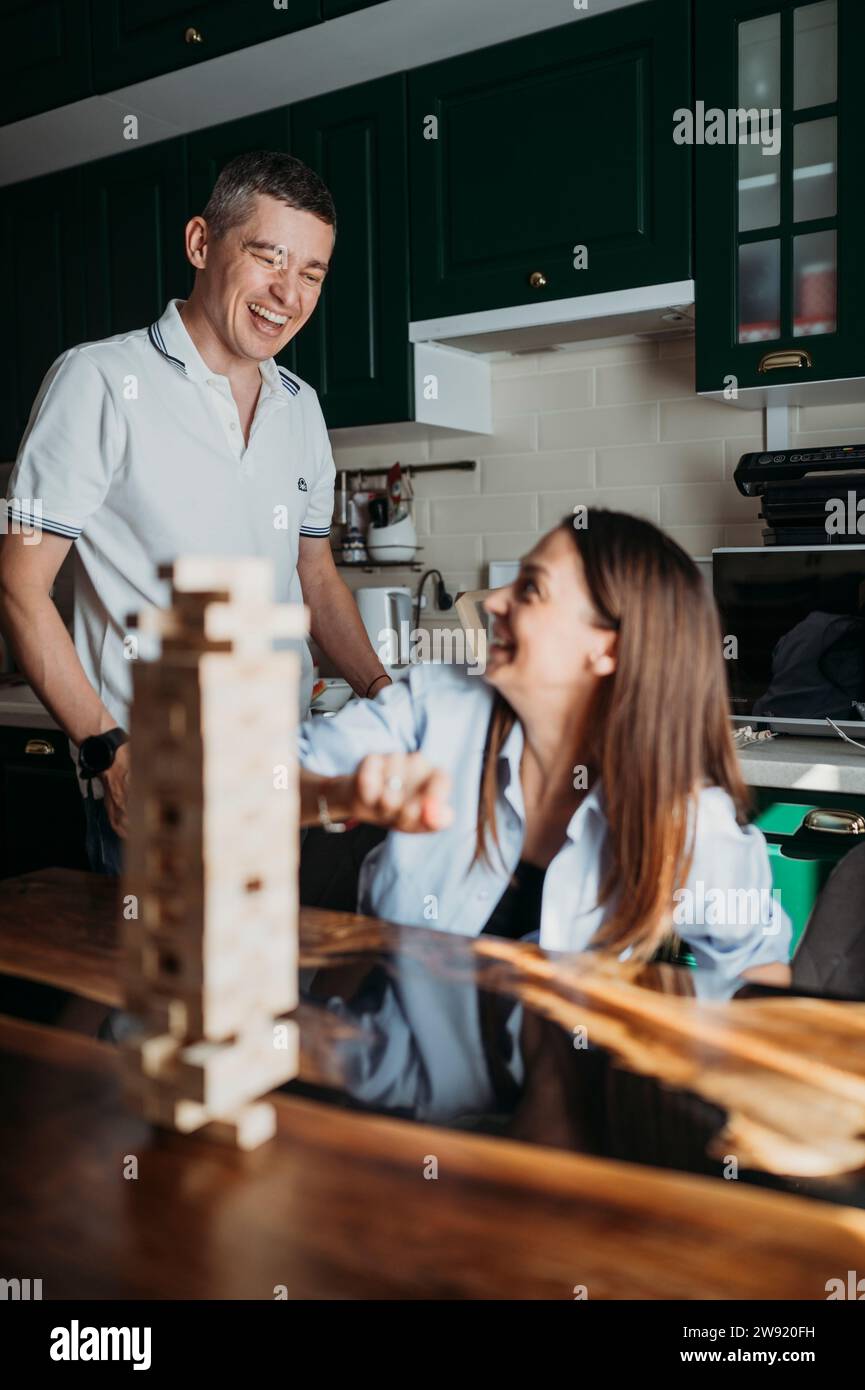 Happy couple playing block removal game in kitchen Stock Photo - Alamy