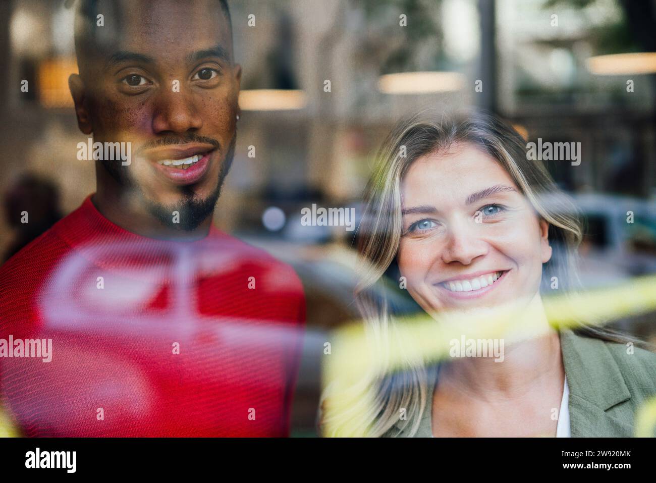 Smiling business colleagues behind glass window Stock Photo - Alamy