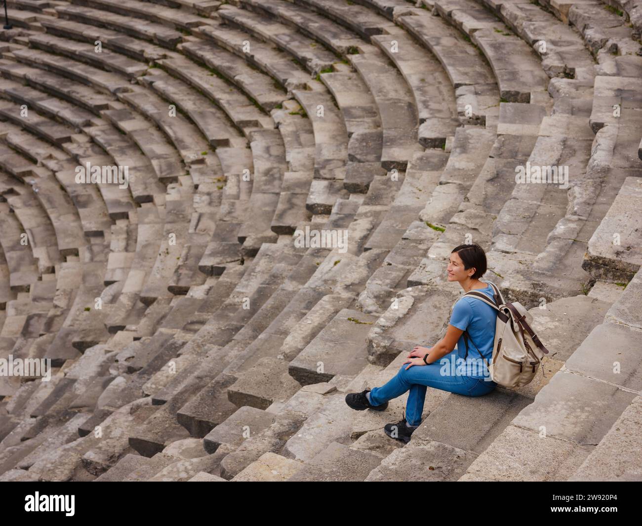 Woman tourist sitting in amphitheater enjoying solitude. travel to ...