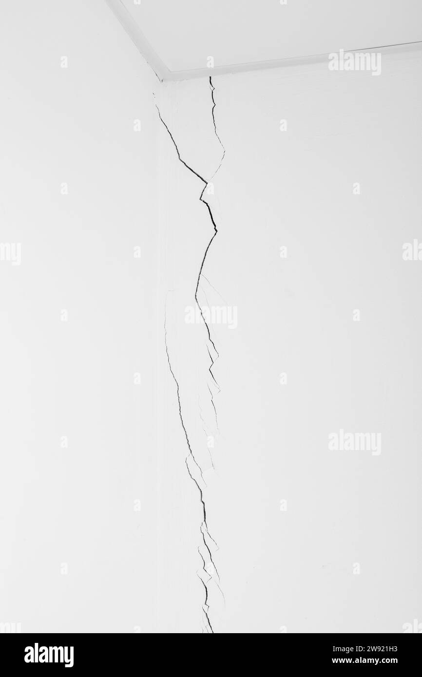 Long, deep crack in the white wall. Construction problems. Shrinkage of ...