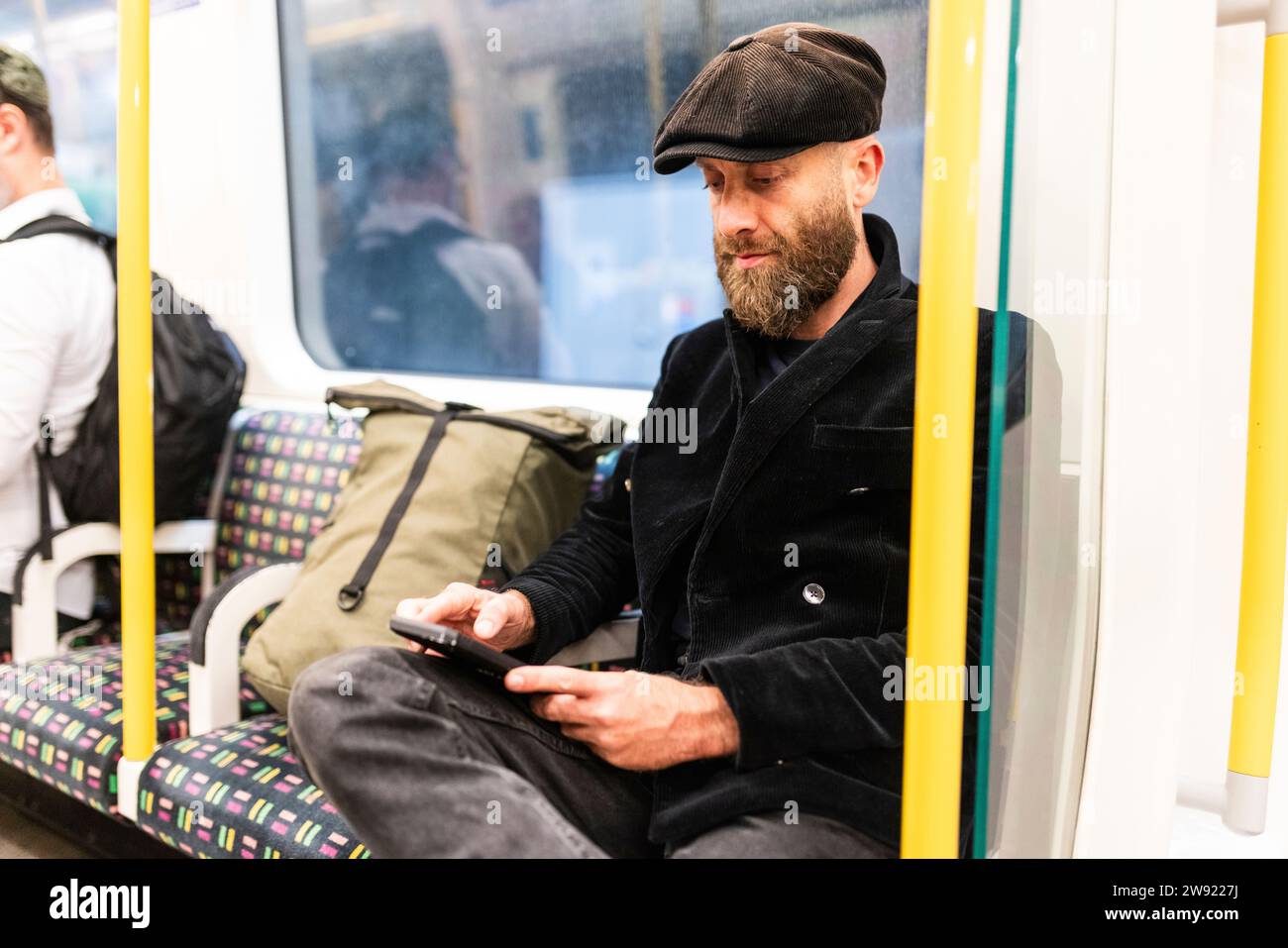 Man using smart phone sitting in train Stock Photo - Alamy