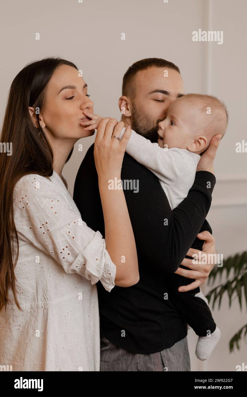 Loving parents kissing son at home Stock Photo - Alamy