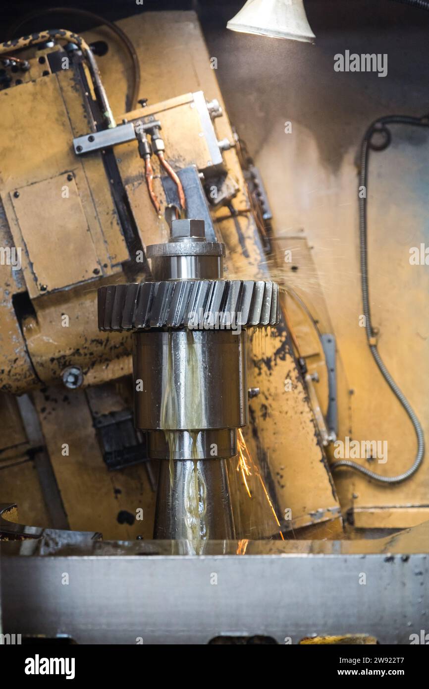 Old machine processes a large metal part. Cutting and cooling of the ...