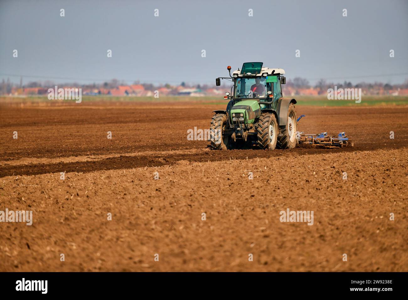 Tractor plowing field in early spring Stock Photo - Alamy