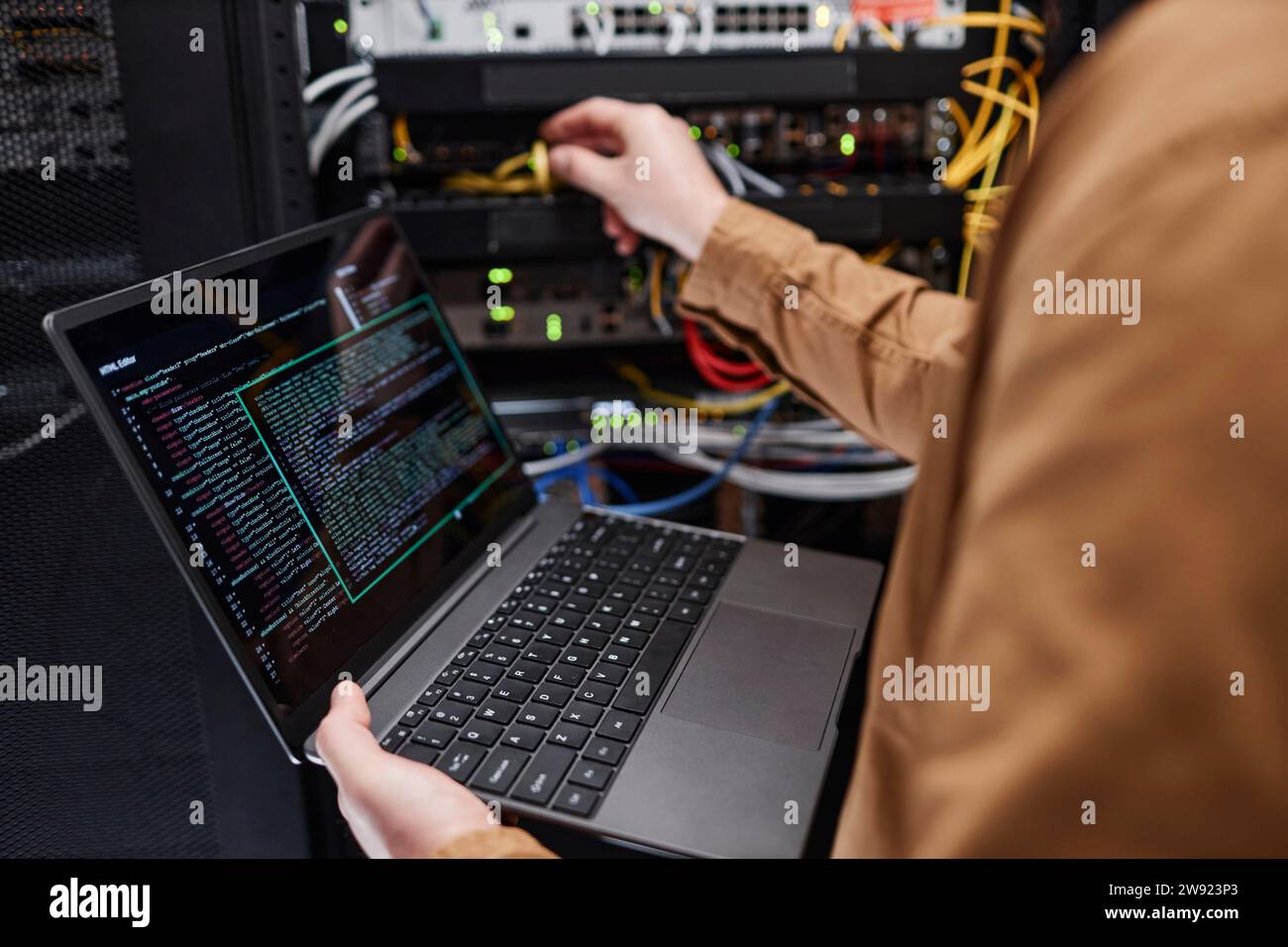 Administrator with laptop working in server room Stock Photo - Alamy