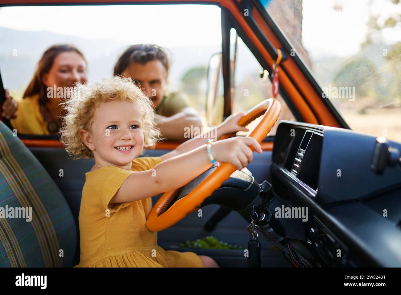 Smiling cute girl playing in caravan by parents on vacation Stock Photo ...