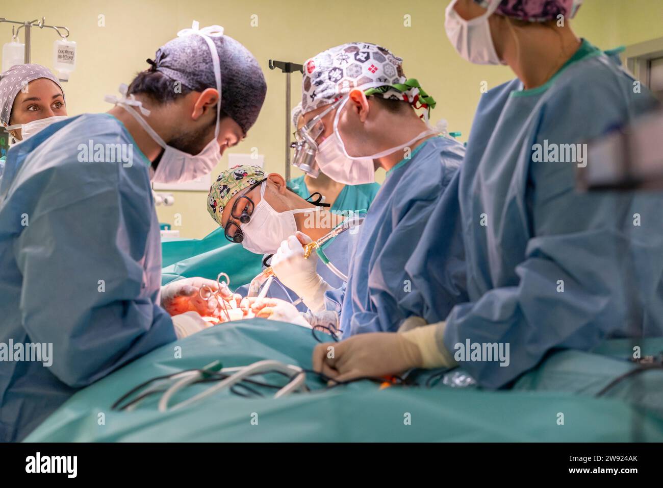Team of surgeons and nurses performing surgery on patient in operating ...