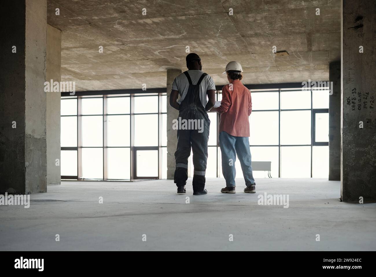 Engineer having discussion with construction worker at site Stock Photo ...