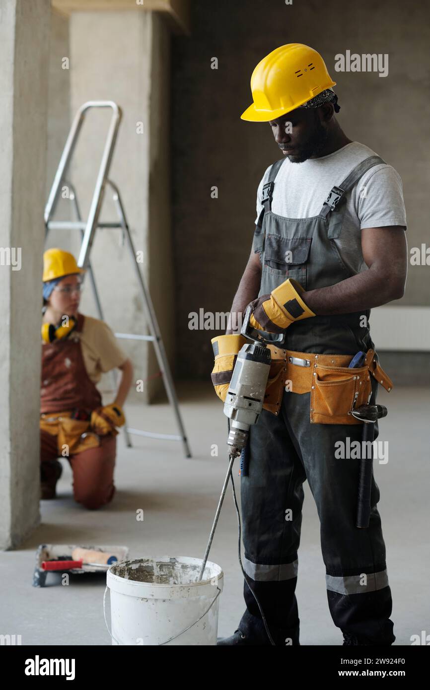 Construction worker mixing cement with tool in bucket at site Stock ...
