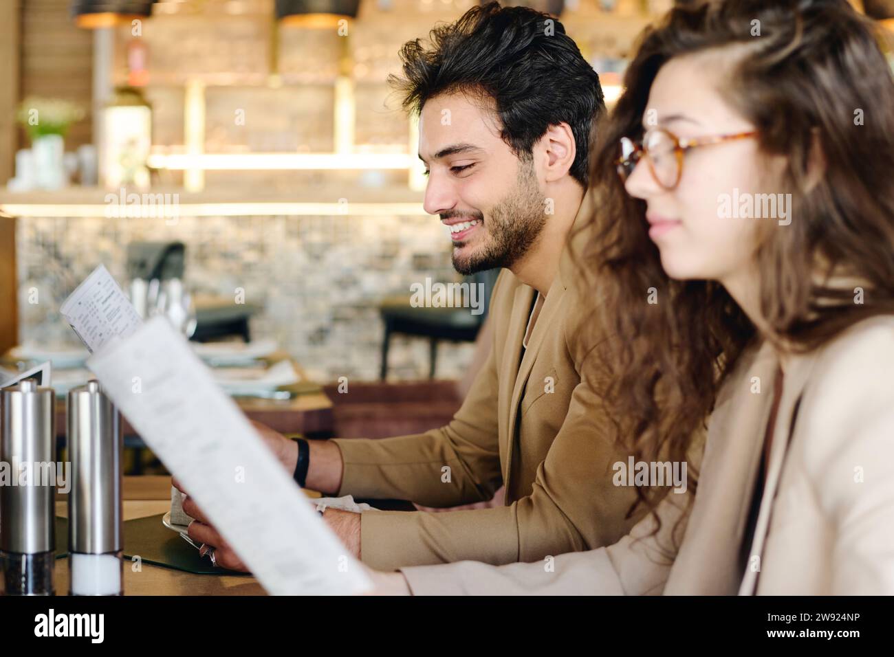 Smiling young colleagues reading menu at restaurant Stock Photo - Alamy