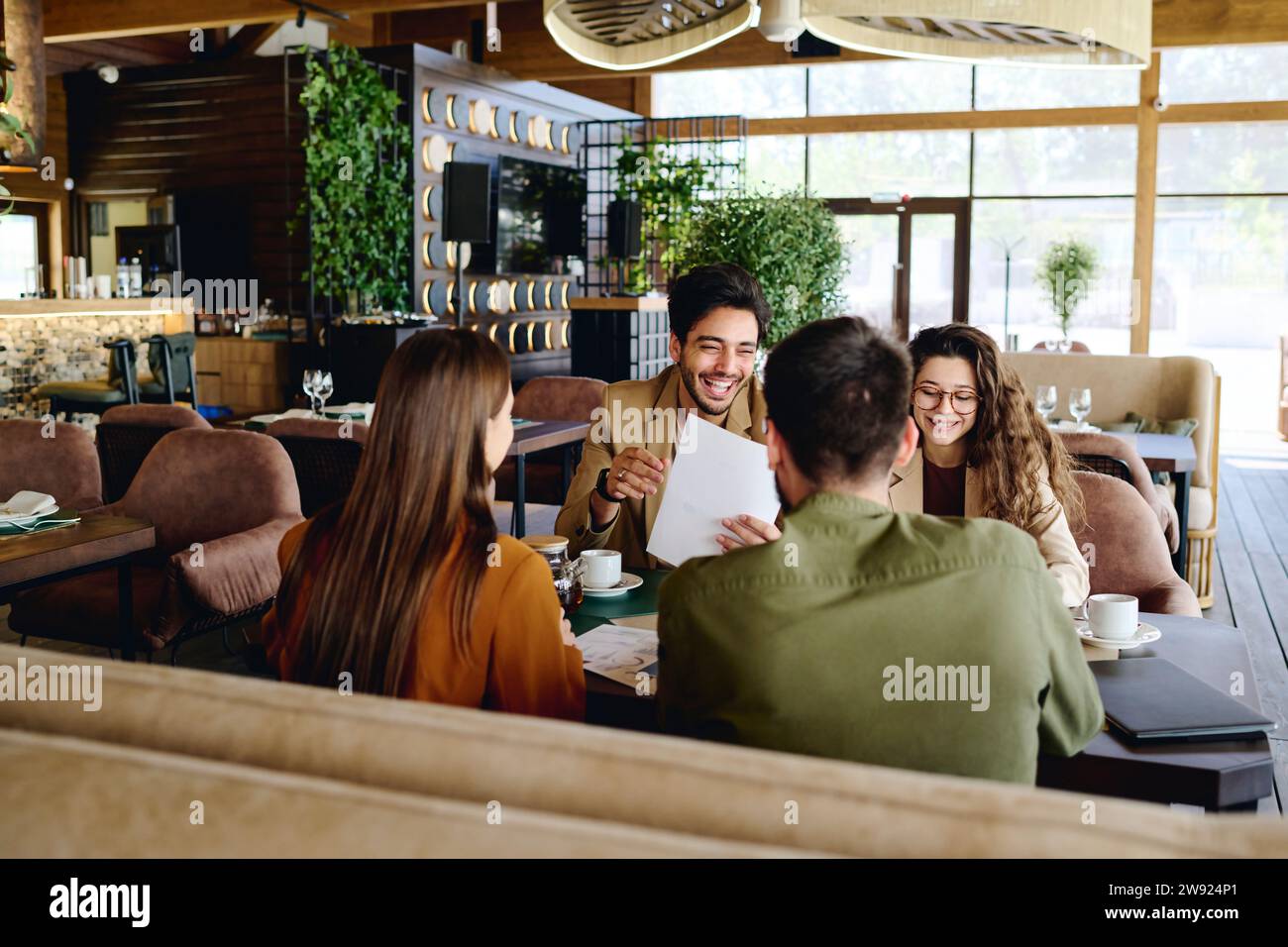 Coworkers enjoying lunch break in restaurant Stock Photo - Alamy