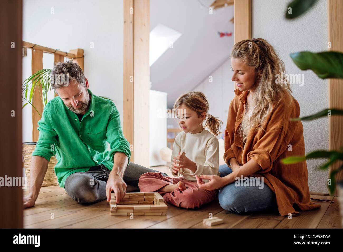 Daughter playing block game with parents at home Stock Photo - Alamy