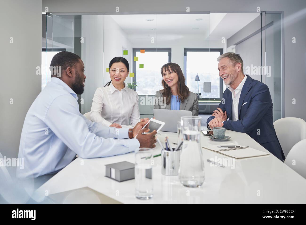 Happy business people having discussion at desk in office Stock Photo ...