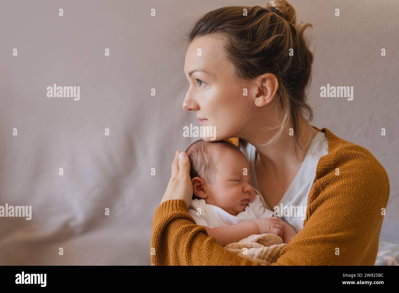 Mother embracing baby boy in arms at home Stock Photo - Alamy