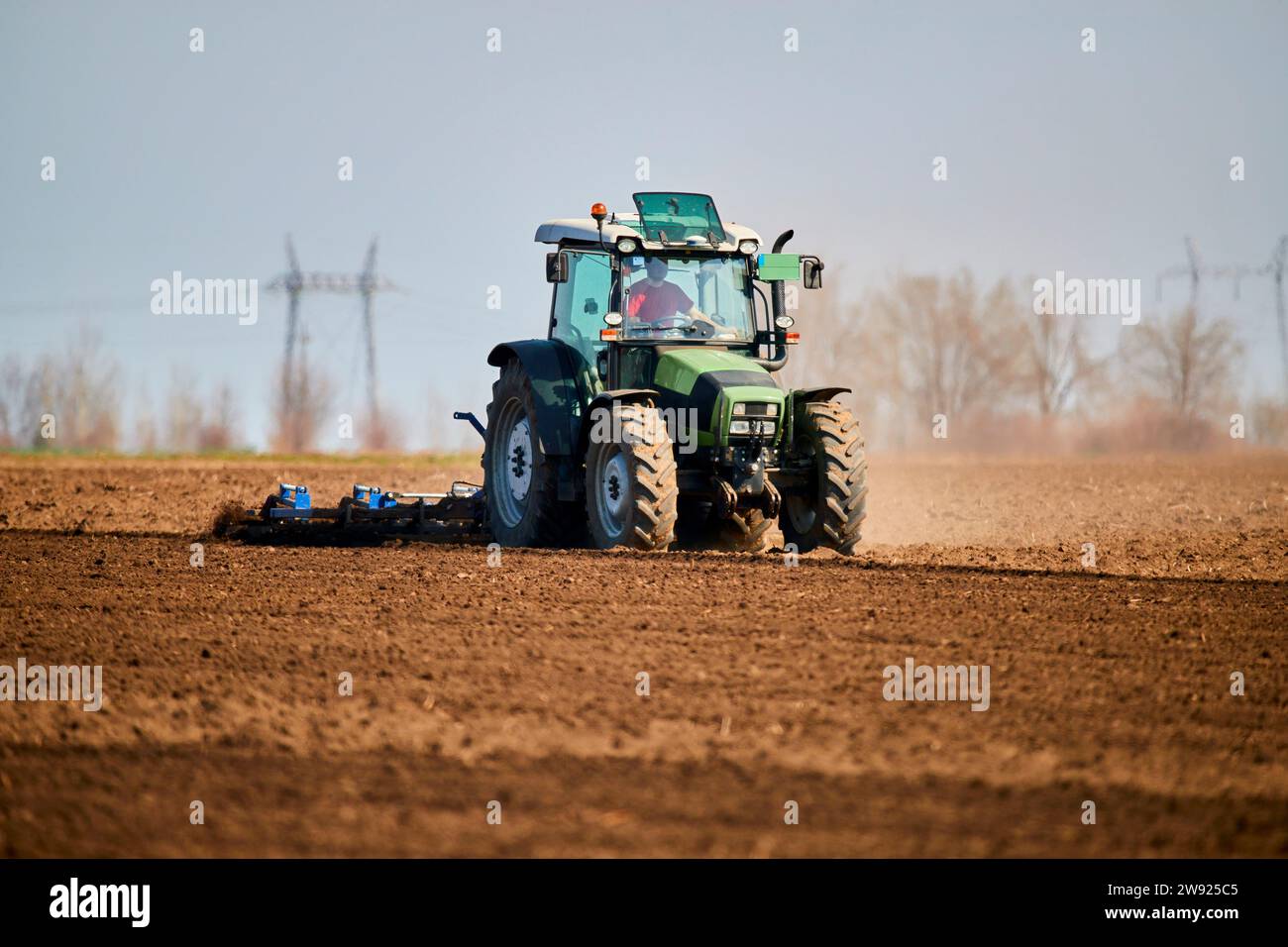 Tractor plowing field in early spring Stock Photo - Alamy