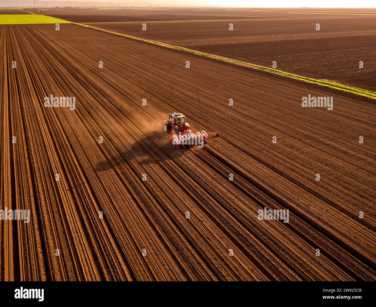 Serbia, Vojvodina Province, Aerial view of tractor sowing seeds in ...