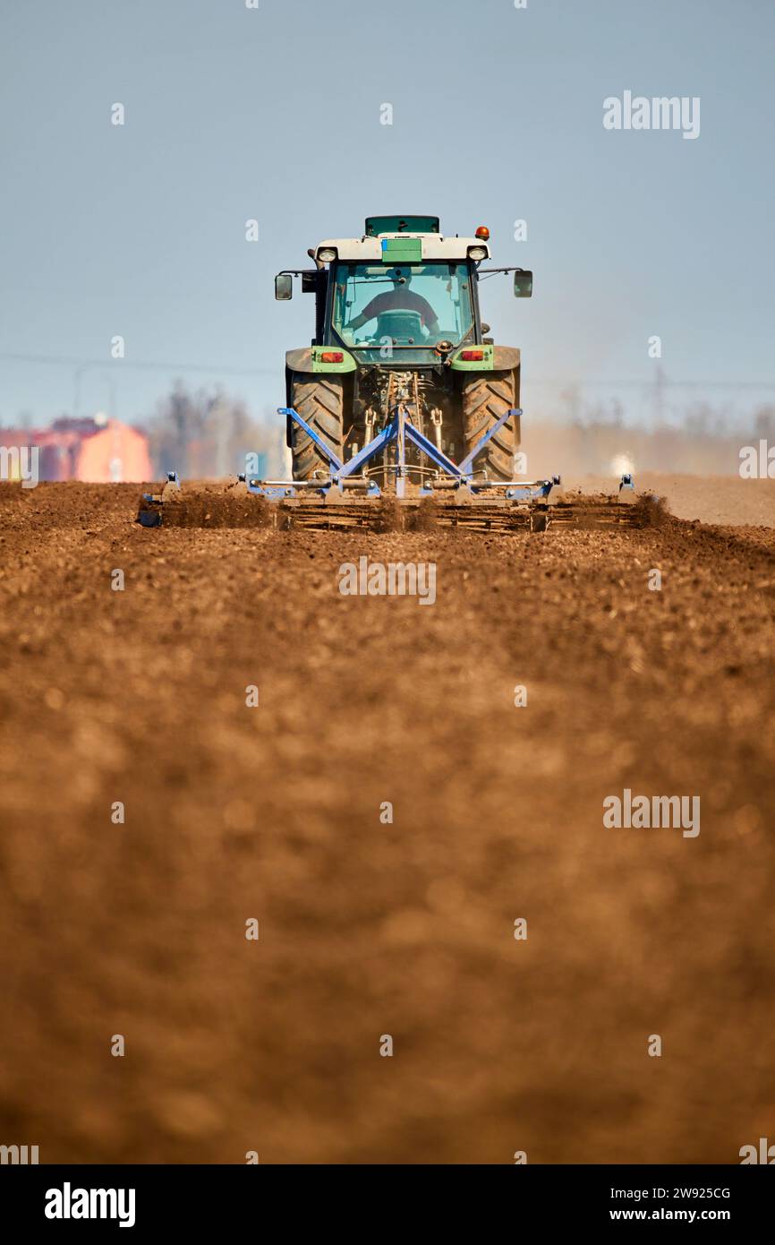 Tractor plowing field in early spring Stock Photo - Alamy
