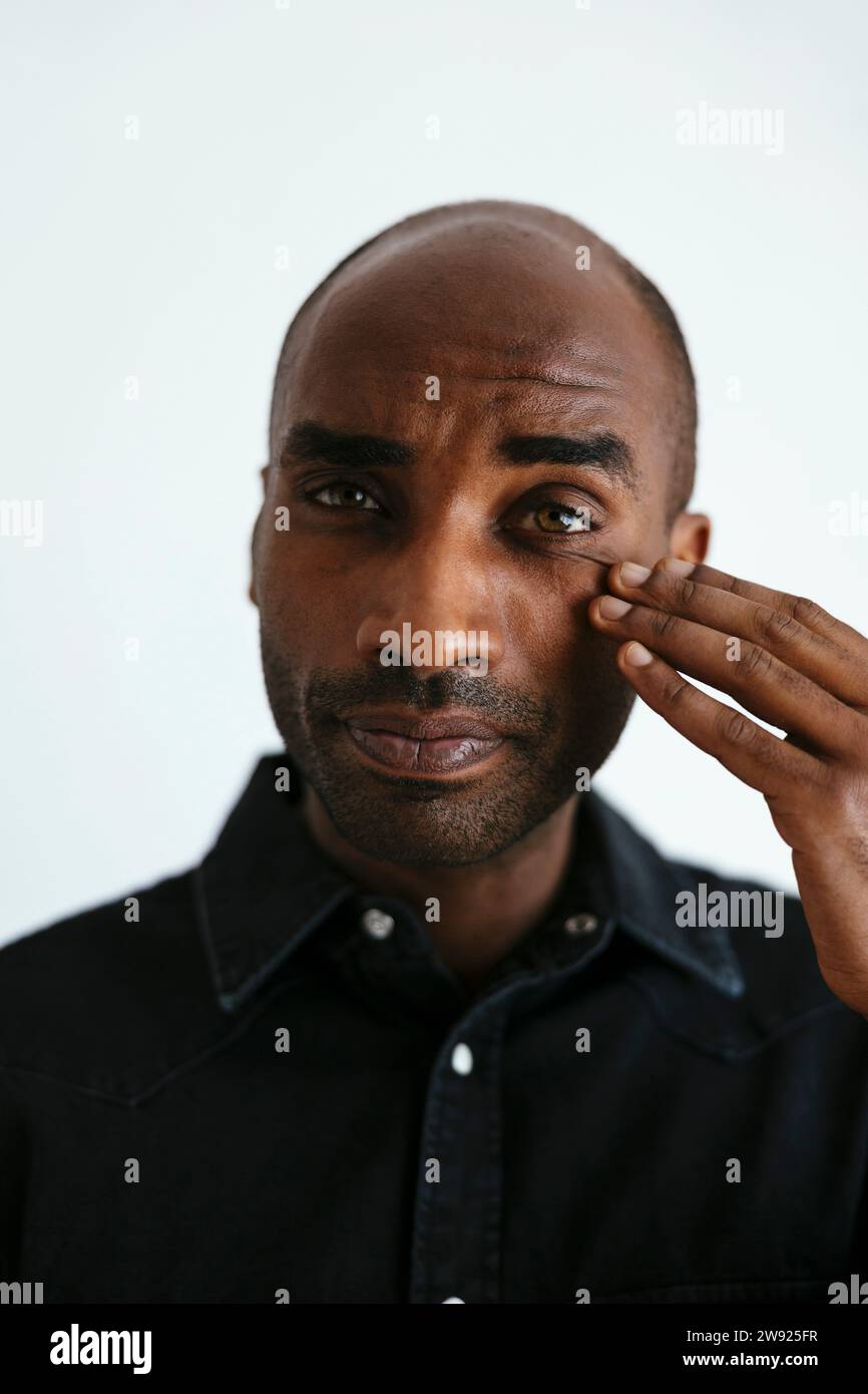 Man touching face against white background Stock Photo - Alamy