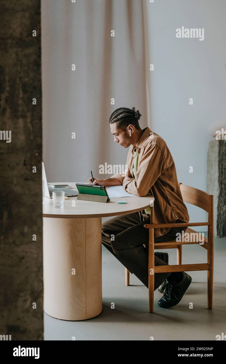 Dedicated young student writing and studying at home Stock Photo - Alamy