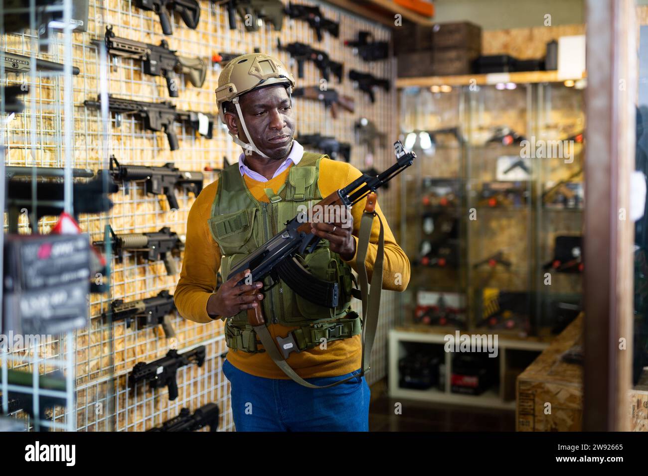 African american guy in military equipment with weapon in army store ...