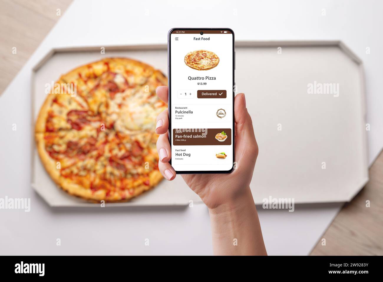 Woman orders and enjoys a Quatro pizza, delivered to her desk via a modern smartphone app ...