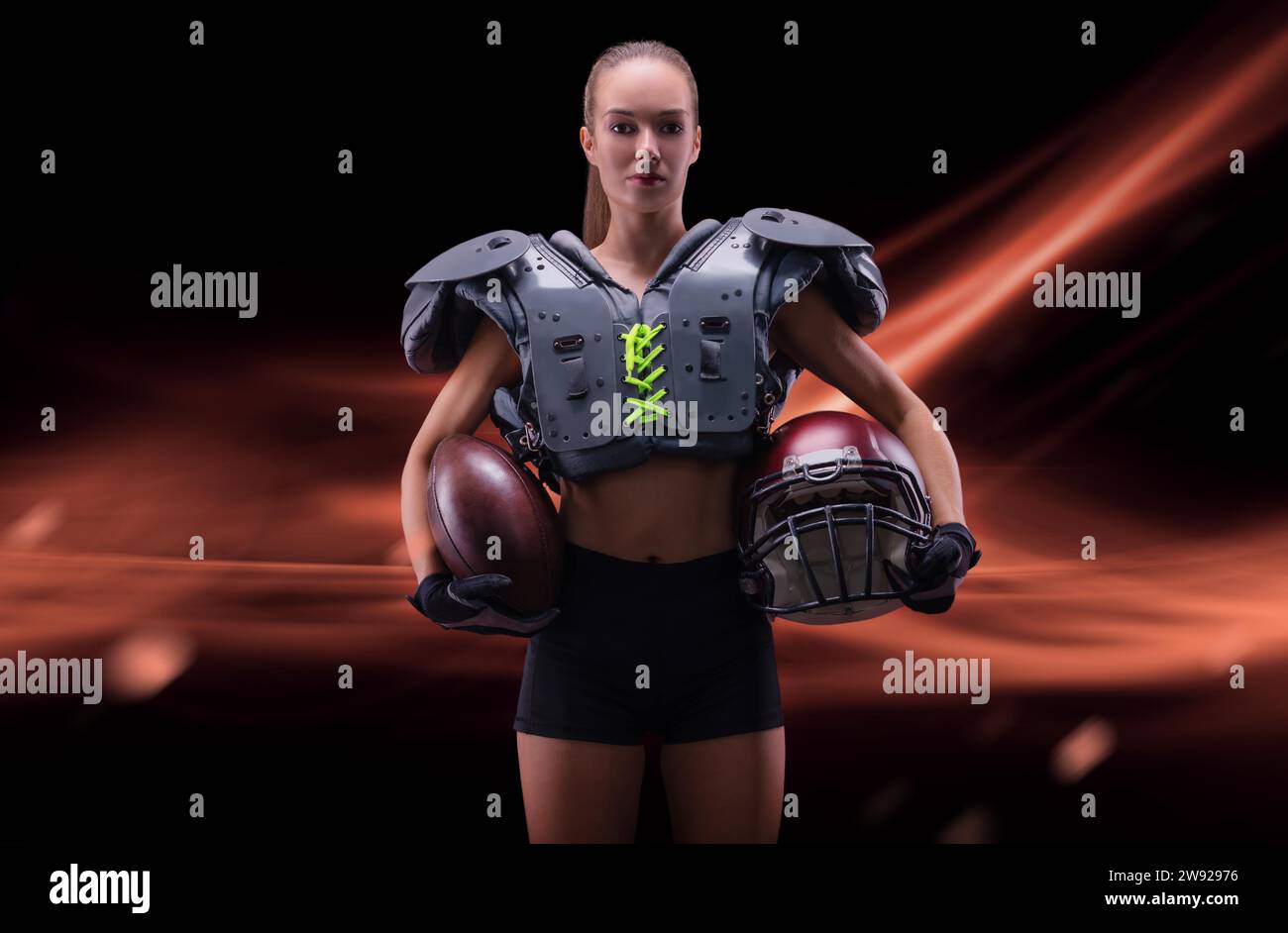 Portrait of a sportive girl in the uniform of an American football team ...