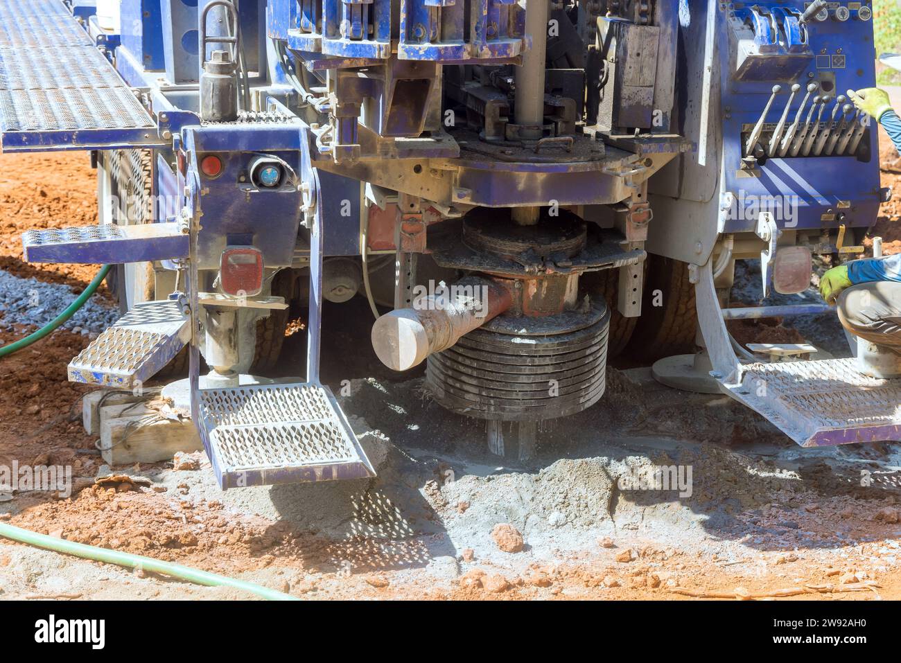This water well is being dug in suburban yard by workmen using drilling ...