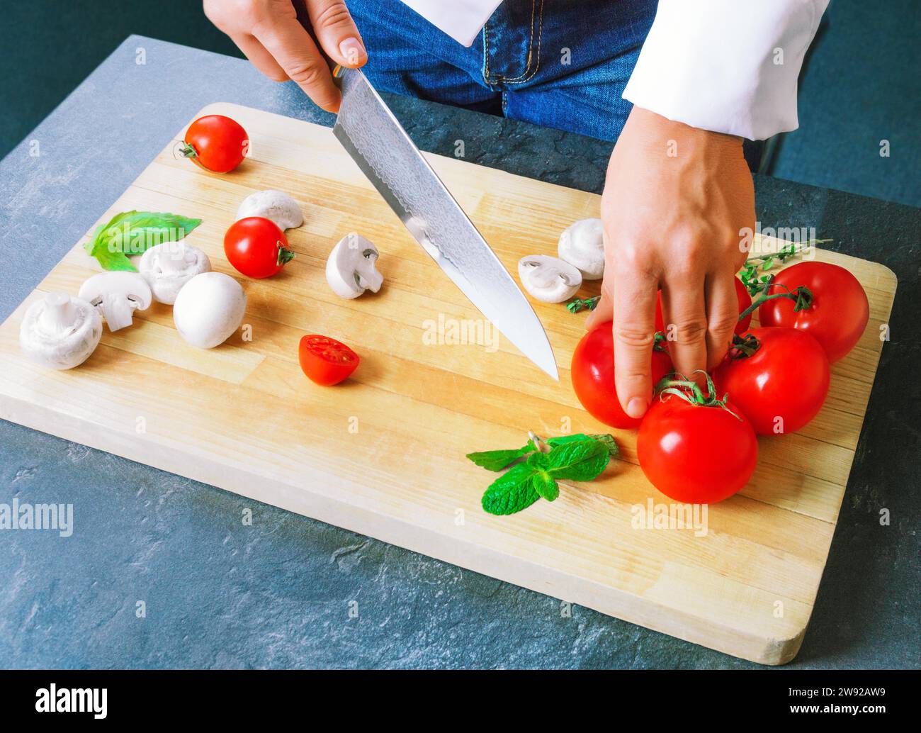 Professional chef cuts vegetables with a sharp knife from Damascus ...