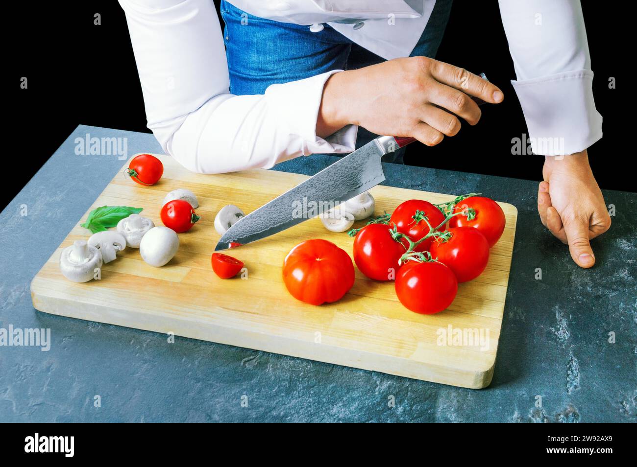 Professional chef cuts vegetables with a sharp knife from Damascus ...