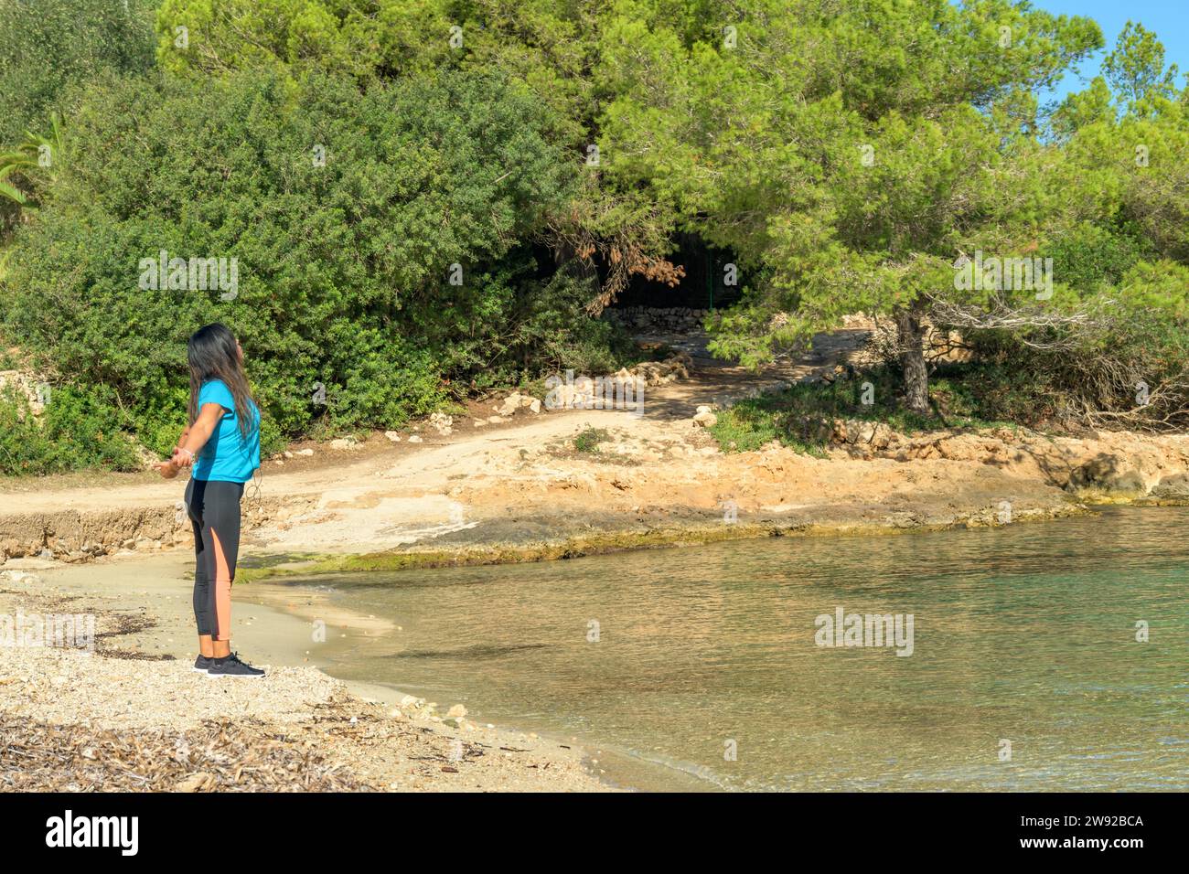 Latina woman, on the shore of the beach looking at the sea breathing ...