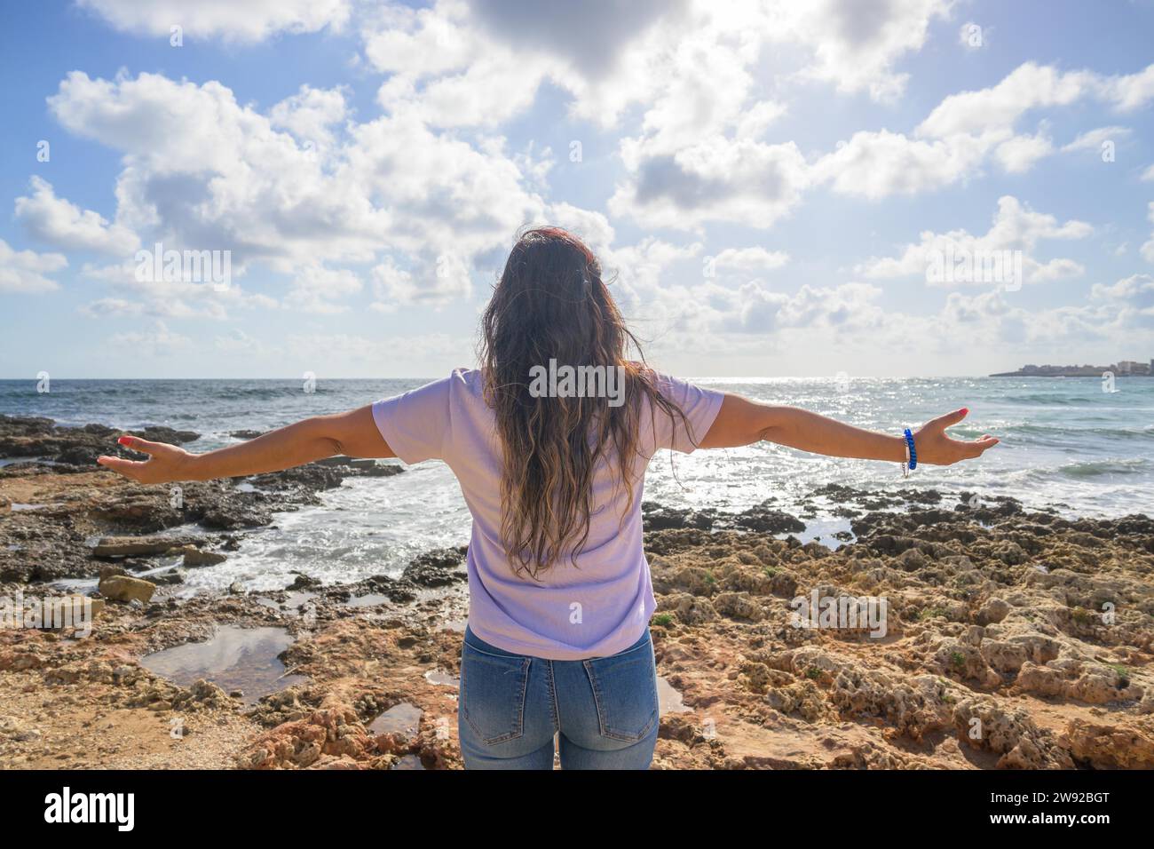Middle-aged woman stretching her arms breathing fresh air on the ...