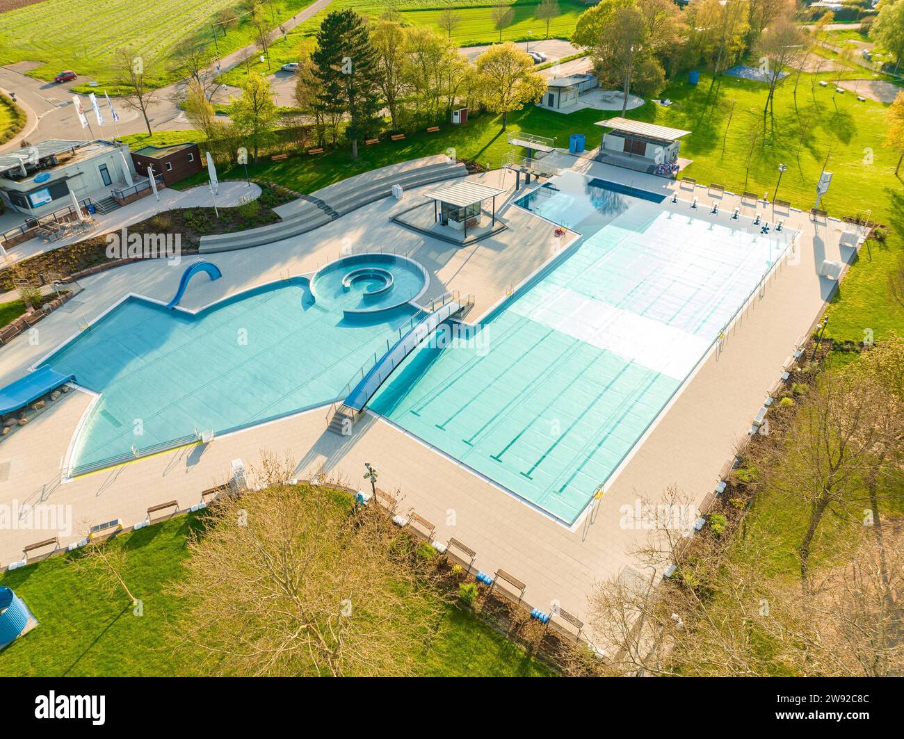 Swimming pool shines in the sunrise, shrouded by soft fog, aerial view ...
