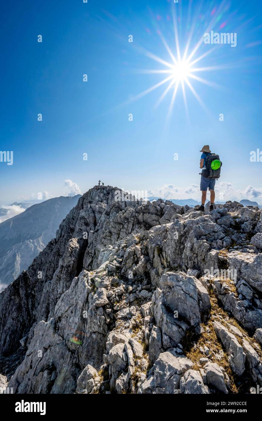 Mountaineer on rocky mountain path, behind summit of Hochkalter, rocky ...