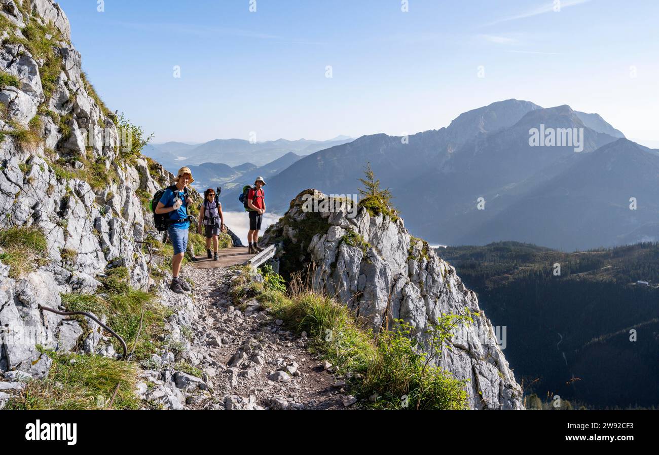 Three mountaineers on a hiking trail, view of mountain panorama, ascent ...
