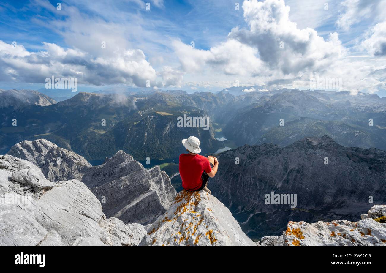 Mountaineer sitting on a rock on the summit of the Watzmann ...