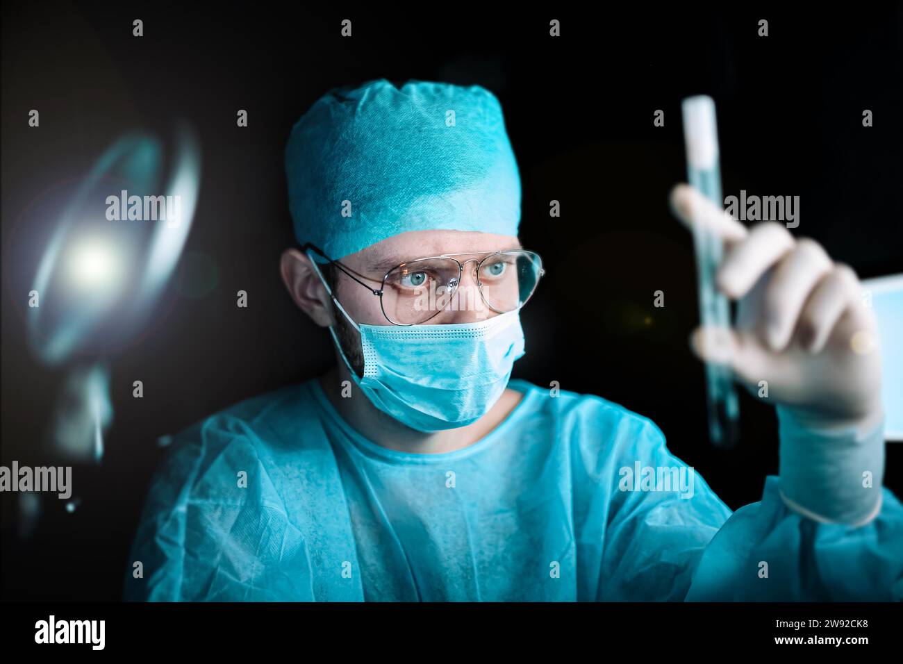 Scientist doctor in a dark laboratory with a test tube of a medicinal ...