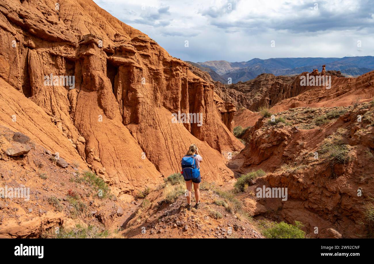 Climber in a canyon with a dry stream bed, eroded mountain landscape ...