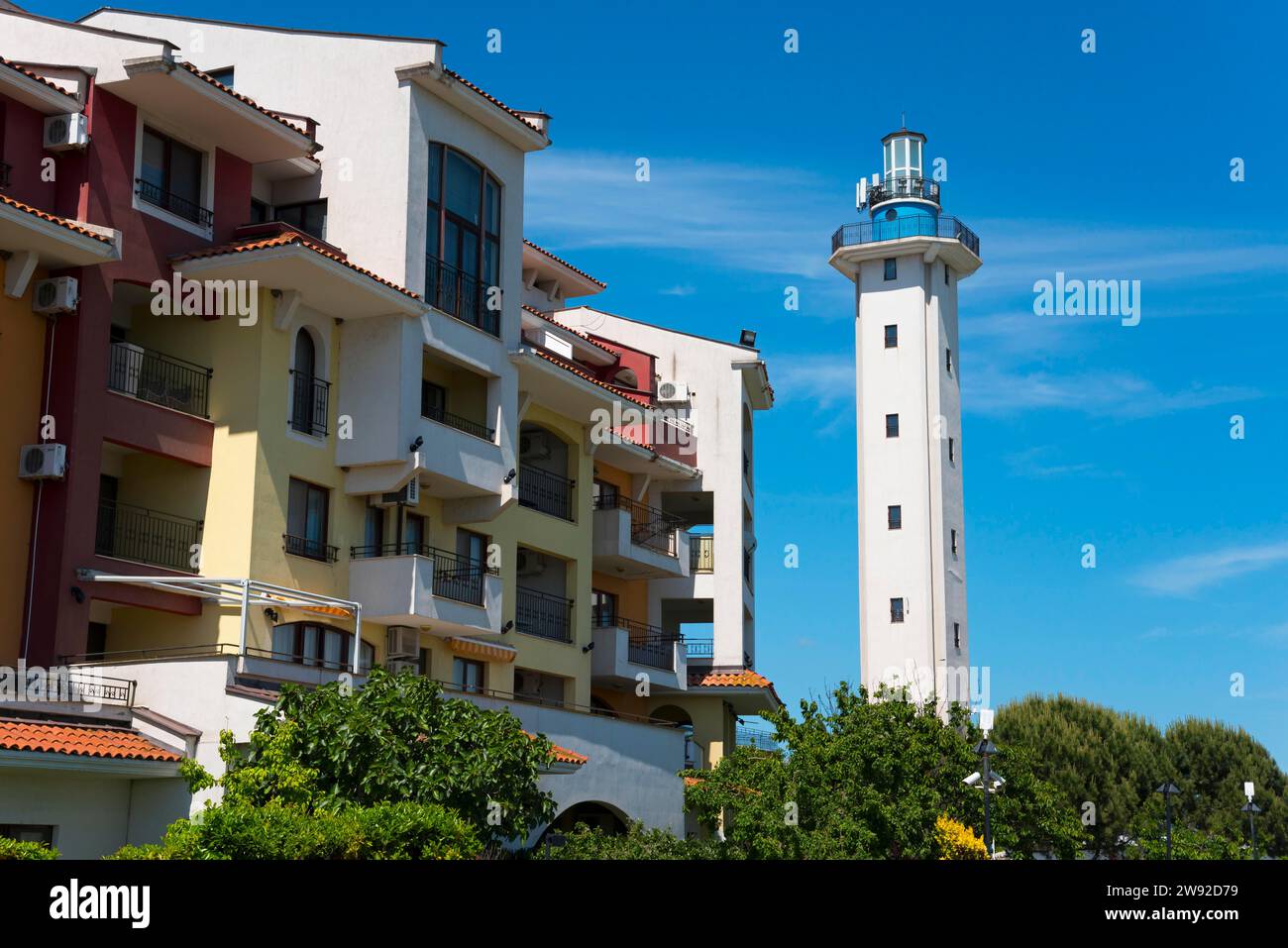 White lighthouse at a hotel complex under a clear blue sky, lighthouse ...