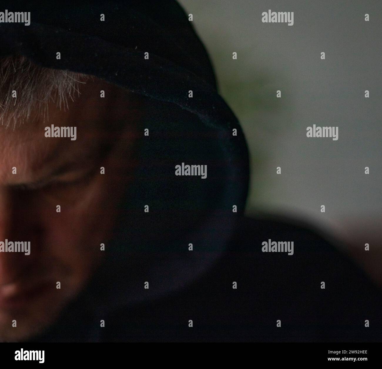 Man looked like hacker in a hood looking at the screen Stock Photo - Alamy